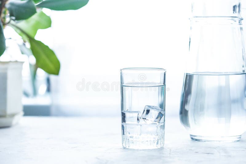 Glass Cup and Carafe with Water and Ice on a White Table Stock Photo ...