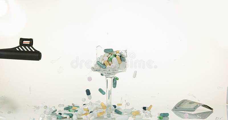 Glass Filled with Capsules and Dollars Exploding Against White ...