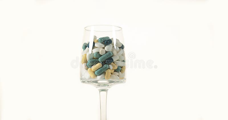 Glass Filled with Capsules Exploding Against White Background Stock ...
