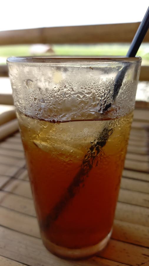 A Glass Filled with Cold Sweet Iced Tea on a Bamboo Table Stock Image ...