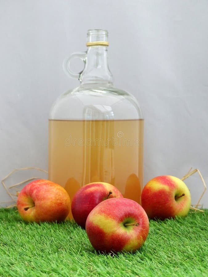 Glass Flagon of Cloudy Cider and Apples on Grass Stock Image - Image of ...