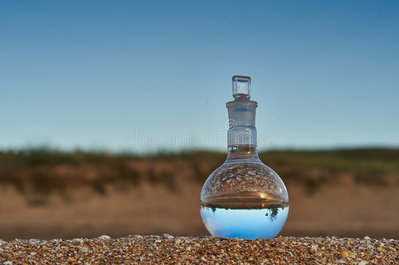 Glass flask by the sea stock photo. Image of education - 230800982