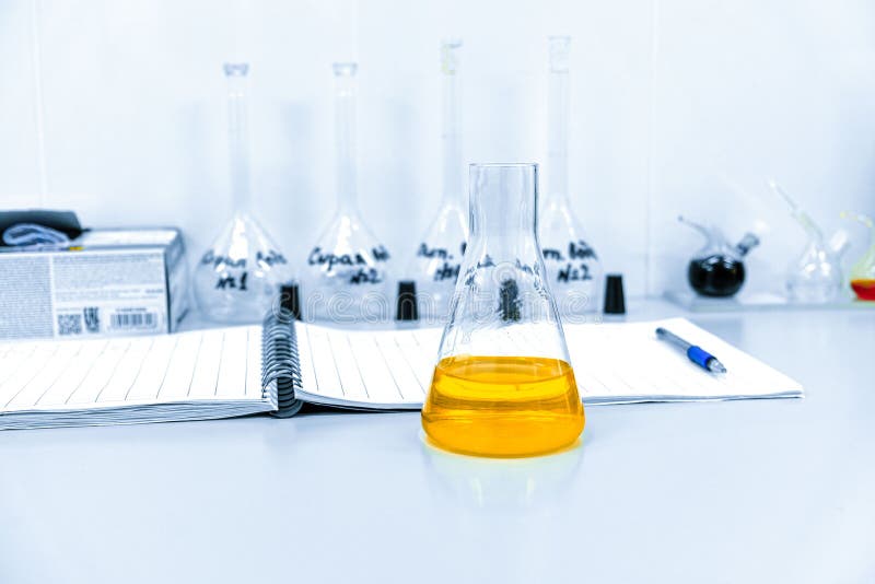 A Glass Flask with a Yellow Reagent is on the Table in the Laboratory ...
