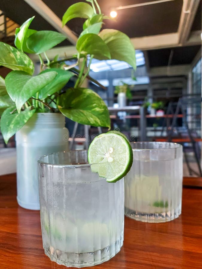 A Glass of Fresh Lime Drink Squeezing with Chugs of Ice Cubes and Lime ...