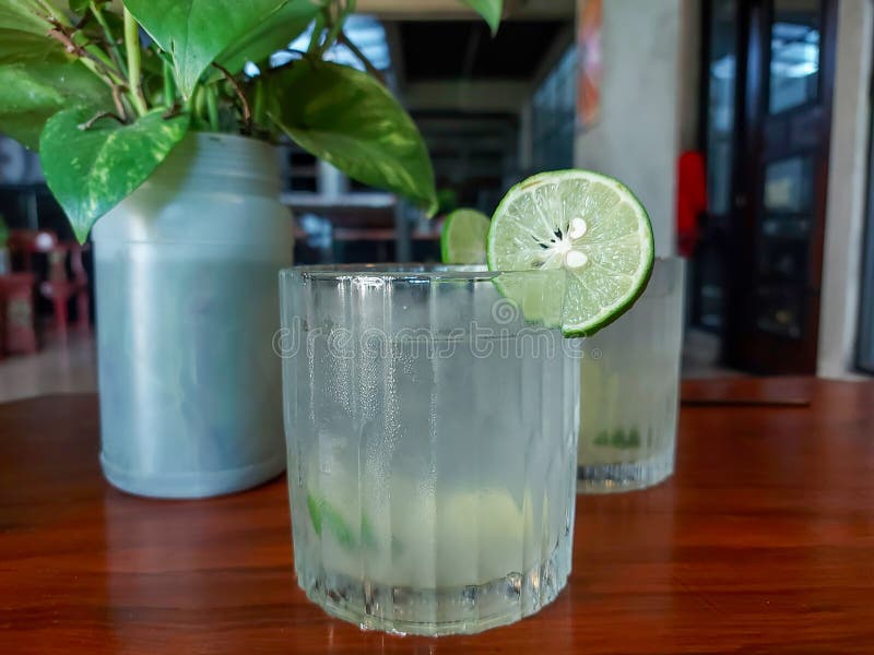 A Glass of Fresh Lime Drink Squeezing with Chugs of Ice Cubes and Lime ...