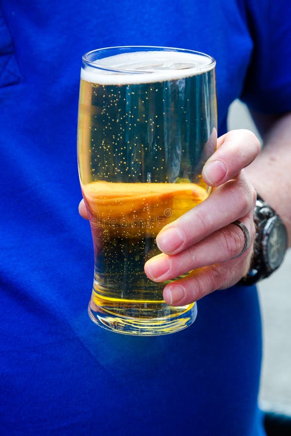 Glass full of beer in hand stock photo. Image of foam - 79208572