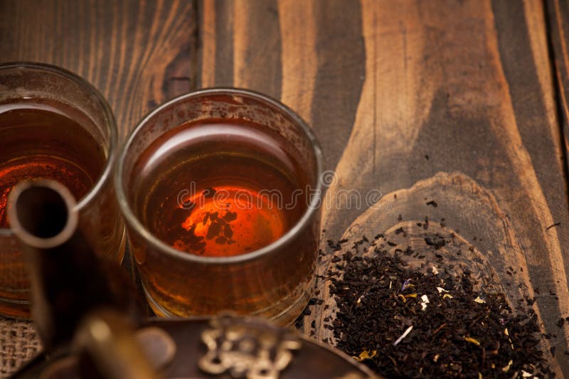 Glass of Hot Tea and Leaves on Dark Wooden Background Stock Image ...