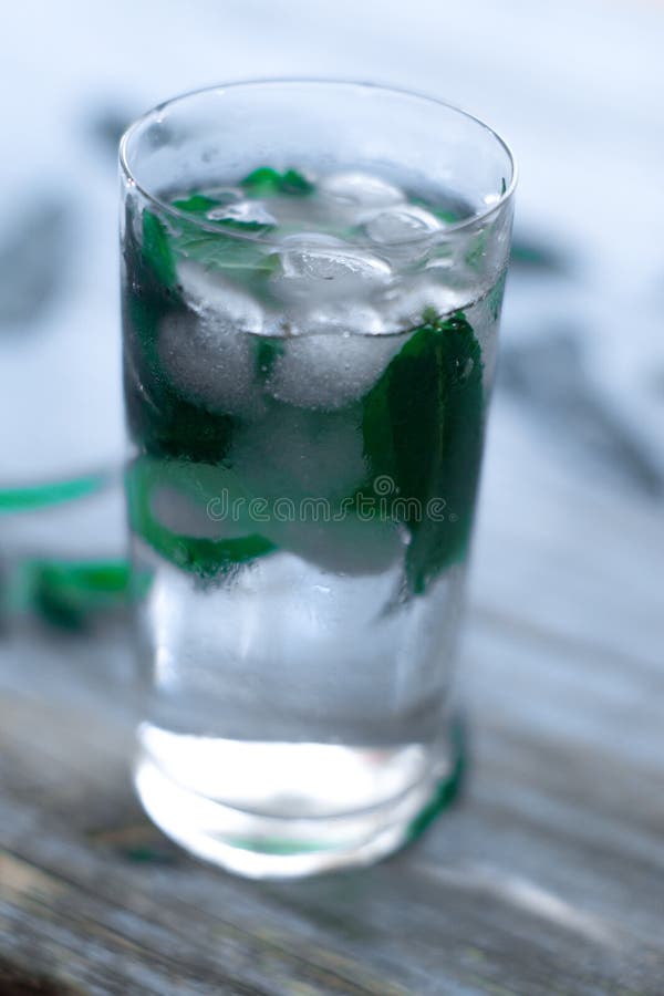 Glass with Ice and Mint Leaves on a Blue Background. Stock Photo ...