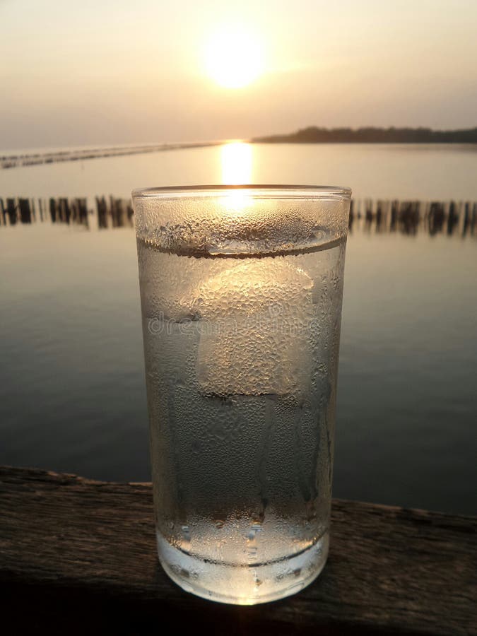 Glass of Ice Water and Sun Set View Stock Image - Image of view, light ...