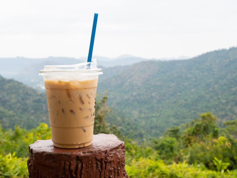 A Glass of Iced Coffee is Placed on the Fence Against a Backdrop of ...
