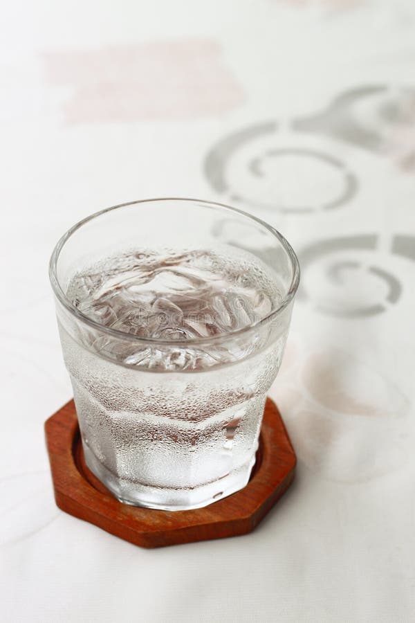 Glass of Iced Water on Wooden Coaster Stock Photo - Image of blurred ...