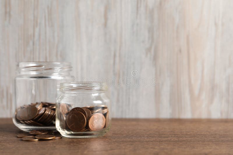 Glass Jars with Coins on Wooden Table. Space for Text Stock Photo ...