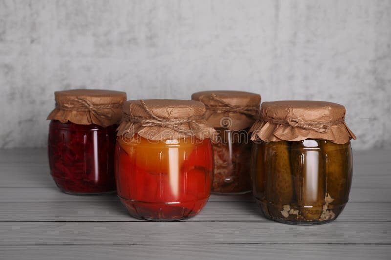 Glass Jars with Different Preserved Vegetables on Wooden Table Stock ...
