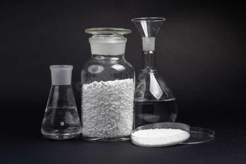 Glass Laboratory Jar with Samples of White Synthetic Rubber on a Black ...