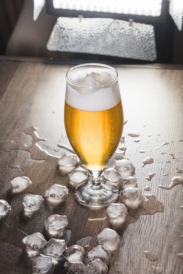 A Glass of Light Beer is on the Table with Ice. the Concept of ...