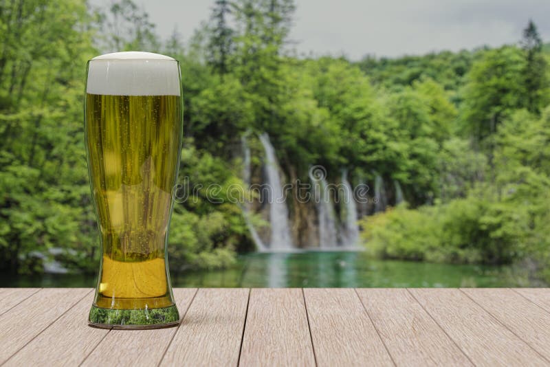 Glass of Light Beer on Table with View of Forest with Lake and ...