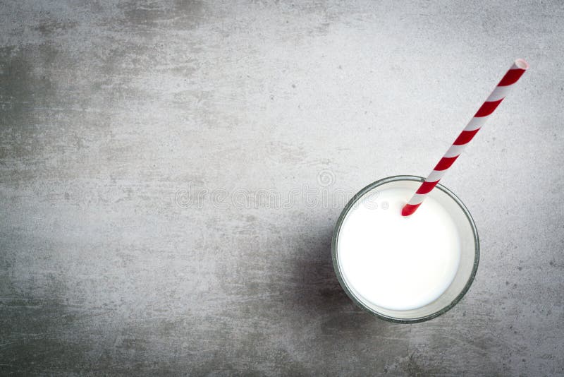 Glass of Milk and a Red and White Drinking Straw on a Concrete T Stock ...