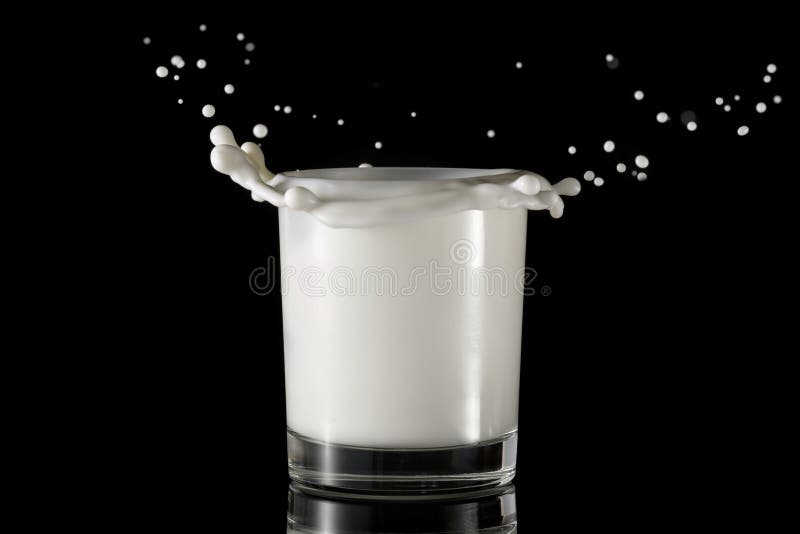 A Glass of Milk with Splashes. a Glass of Milk on Black Stock Photo ...