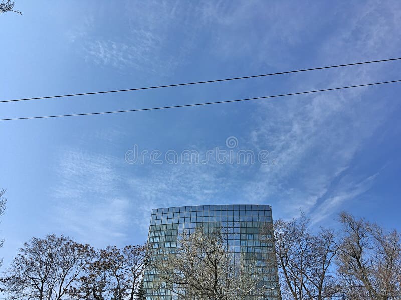 Glass Modern Skyscraper on a Background of Blue Sky with Small Clouds ...