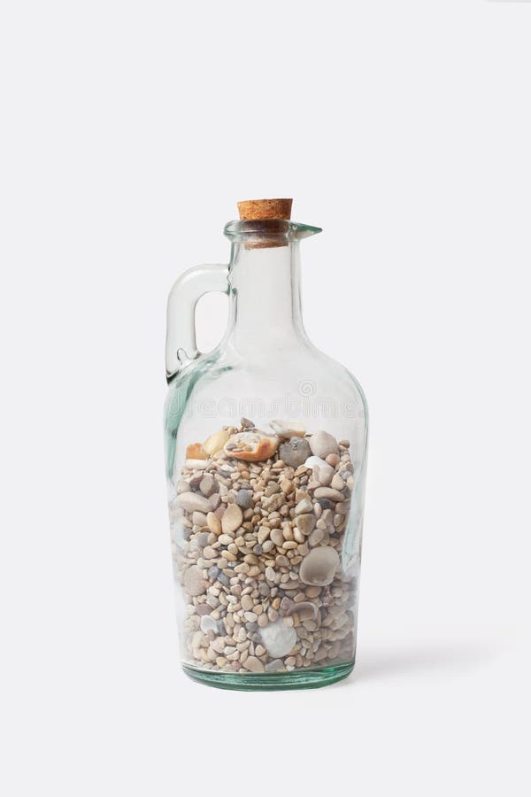 Glass Oil Bottle with Shells and Small Stones Inside on a White ...