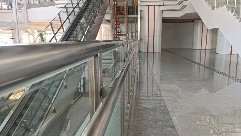 A Glass Railing with a Silver Frame is Seen in a Large, Empty Building ...