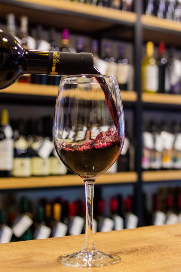 A Glass of Red Wine Being Poured from a Bottle Stock Photo - Image of ...