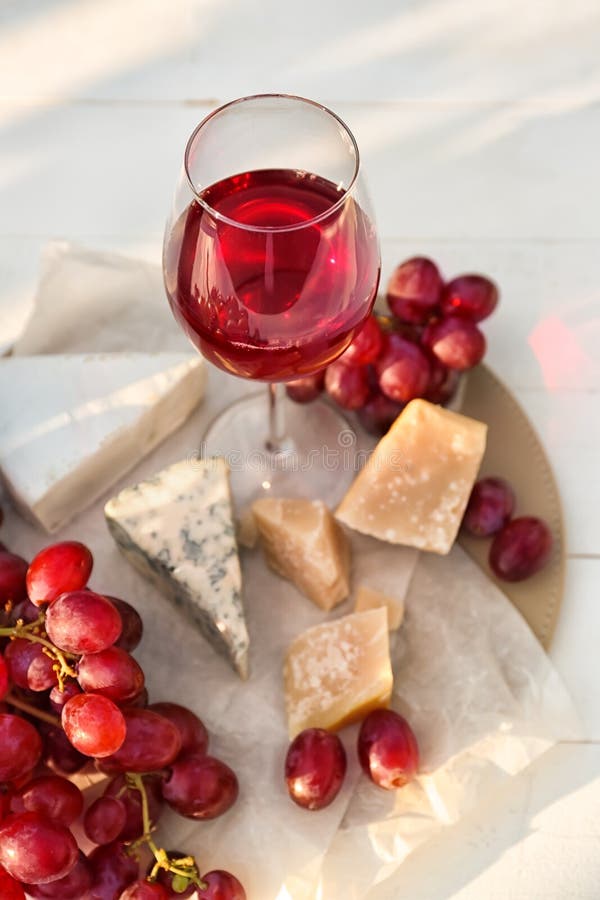 Glass of Red Wine with Cheese and Fresh Grapes on Light Table Stock ...
