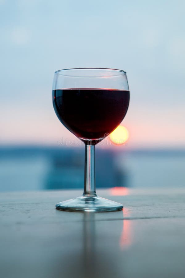 A Glass of Red Wine in Front of the Beautiful Soft Sunset. Stock Photo ...