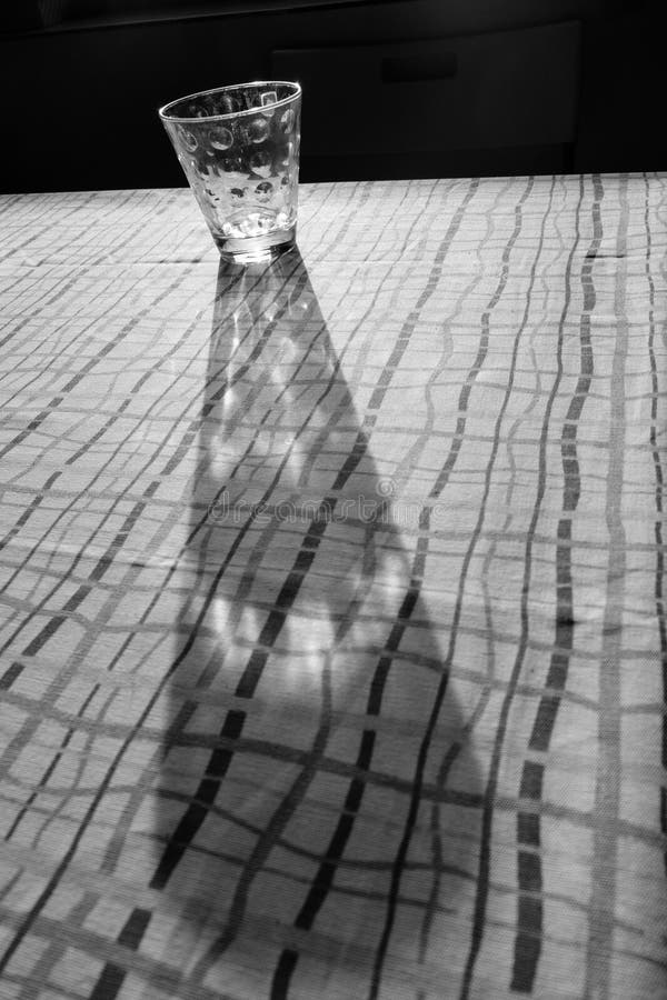 Glass with shadow on table stock photo. Image of table - 238046334