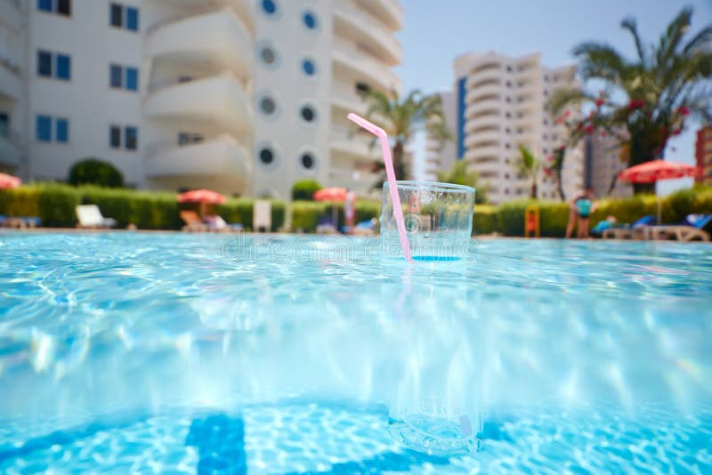 Glass with Sipper Straw Floats in Pool Stock Image - Image of poolside ...