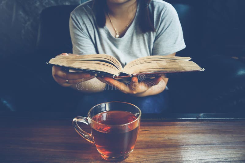 A Glass of Tea on Table with Woman Reading Book on Sofa. Stock Photo ...