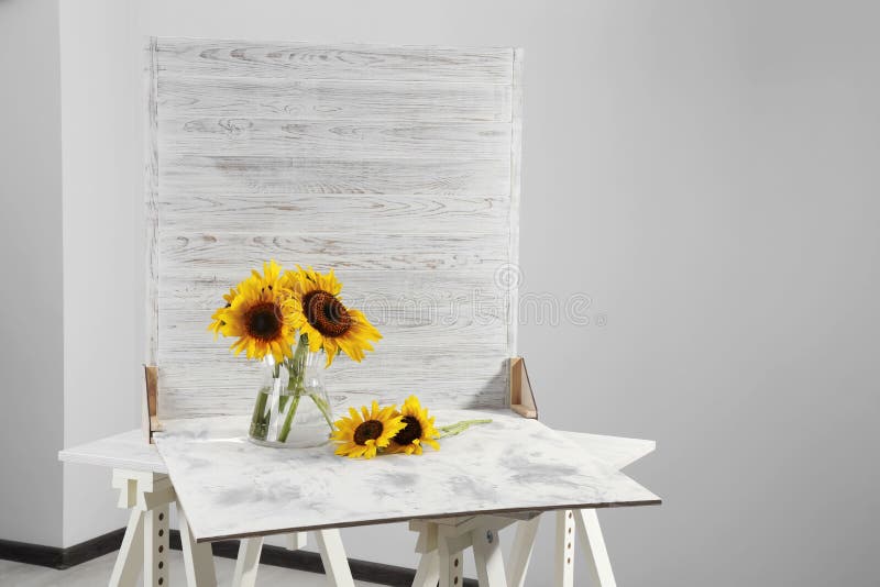 Glass Vase with Beautiful Sunflowers and Double-sided Backdrop on Table ...