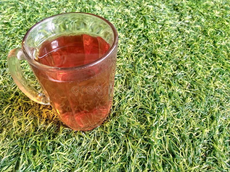 A Glass of Warm Tea on Synthetic Grass, Taken from the Side Stock Photo ...