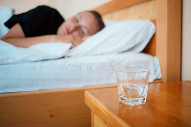 Glass with Water on the Background of a Sleeping Girl Stock Image ...