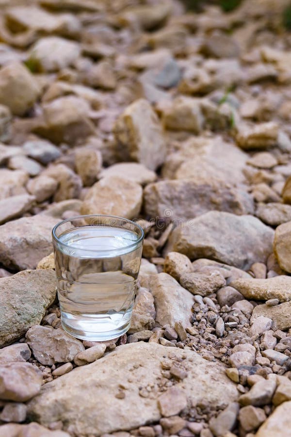 Glass of Water on the Bed of a Dry River, Drought Concept Stock Image ...