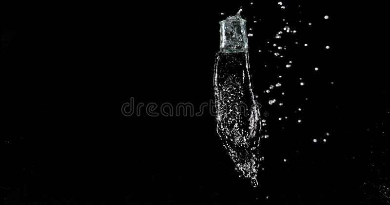 Glass of Water Bouncing and Splashing on Black Background, Slow Motion ...