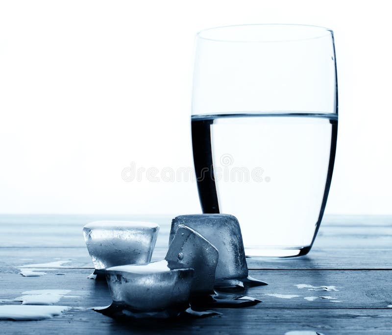 Glass of Water and Melting Ice Cubes on a Wooden Table. Stock Photo ...
