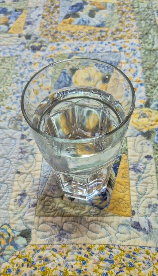 Glass with Water Placed on a Quilt with a Patchwork Design. Stock Photo ...