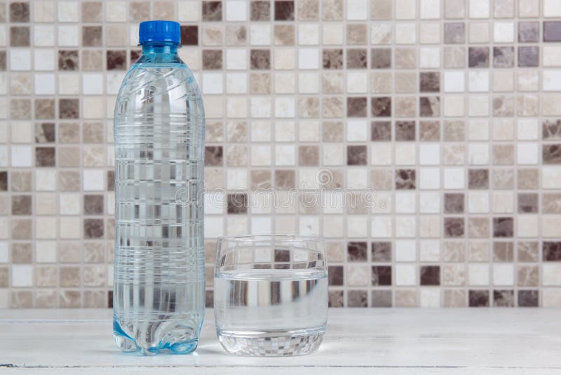 Glass of Water and Plastic Water Bottle on Kitchen Table Stock Photo ...