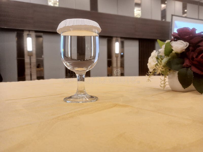 A Glass of Water on the Table with Flowers on the Side Stock Image ...
