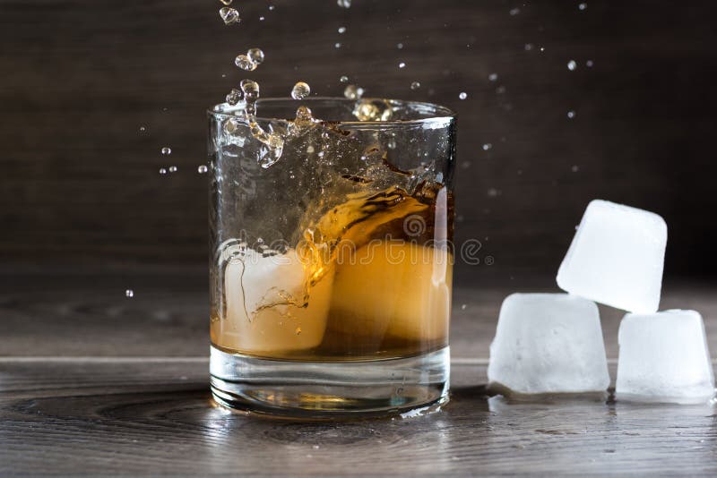 Glass of Whiskey and Splashing from Falling Ice Stock Image - Image of ...