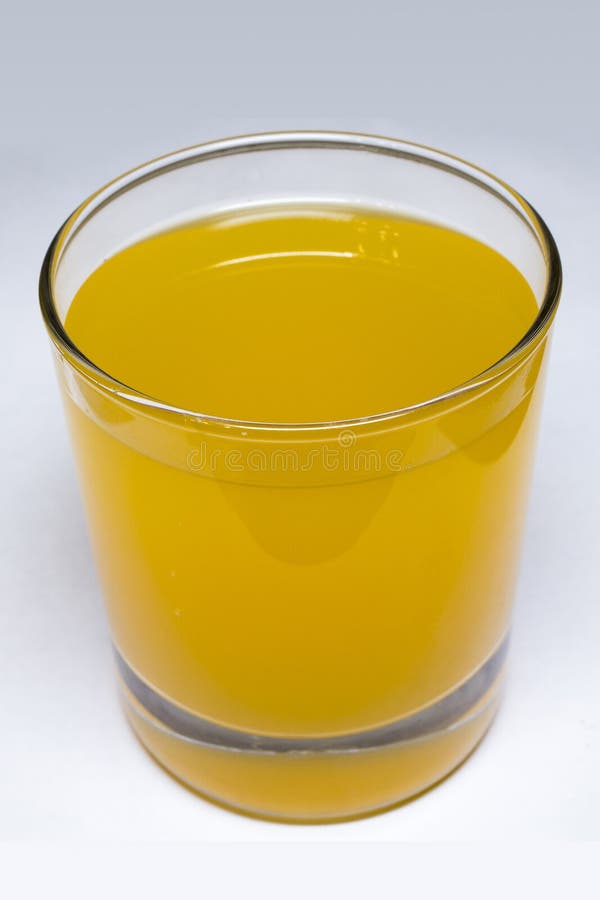 Glass with yellow liquid stock image. Image of drops - 85045545
