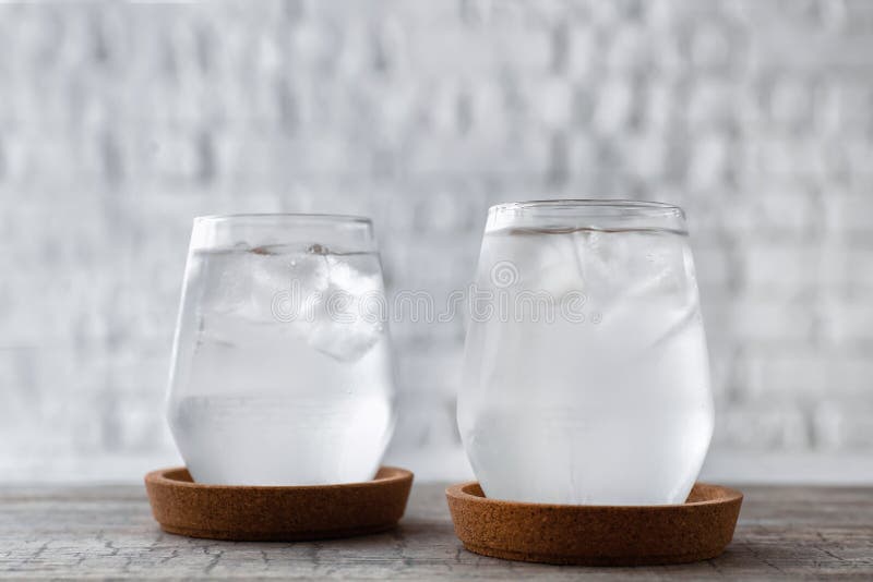 Glasses of Clean Water and Ice Cubes on Wooden Table Stock Photo ...