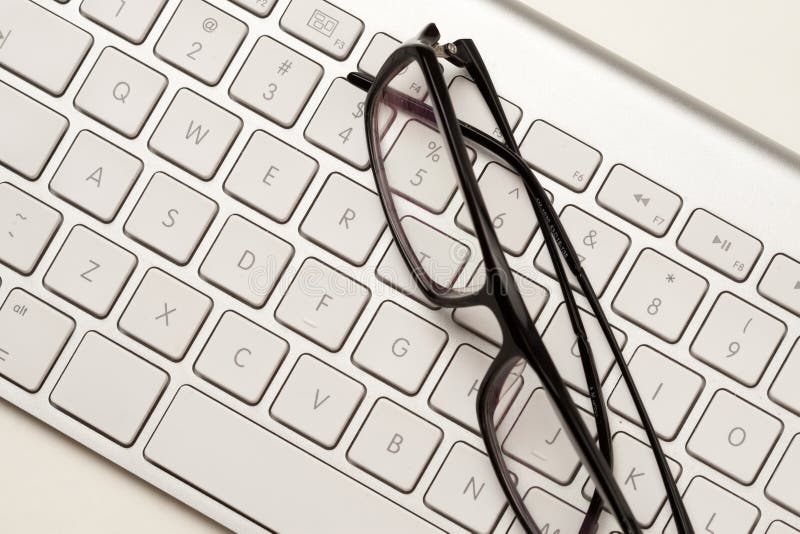 Glasses on a keyboard stock image. Image of computer - 33596469