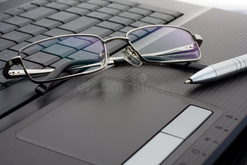 Glasses and pen on laptop stock image. Image of document - 23858589