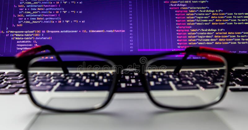 Glasses Placed On The Laptop At The Back Is The Screen Of The Program Source Code That