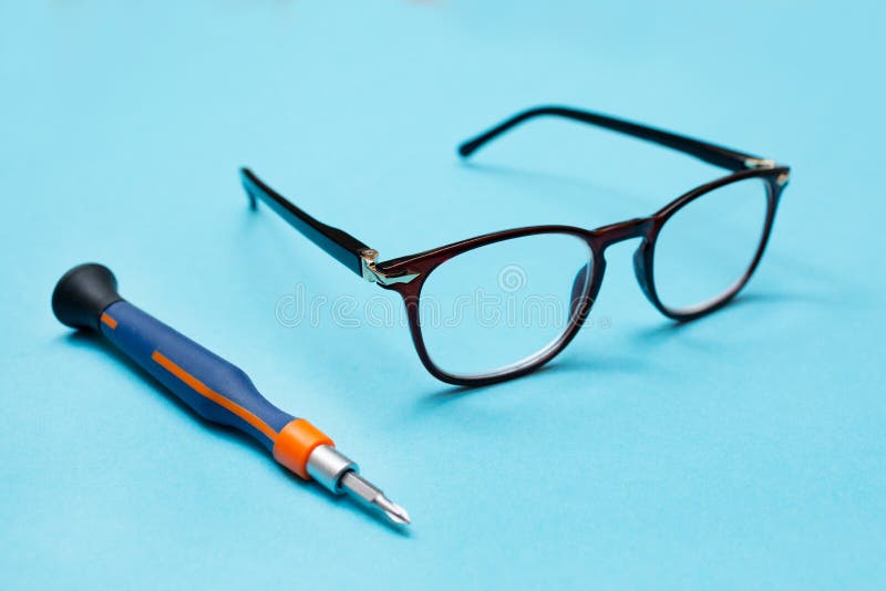 Glasses for Vision and a Screwdriver for Repairs on a Blue Background ...