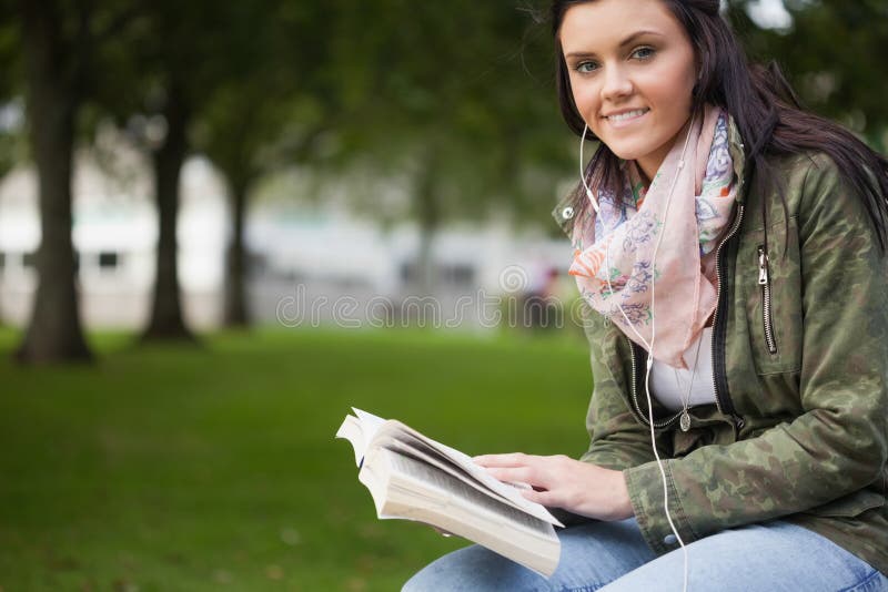 Gleeful Brunette Student Sitting on Bench Reading Stock Photo - Image ...