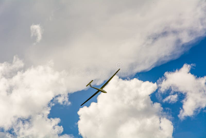 A Glider Flying in Bleu Sky with Big White Clouds. the Glider is a ...