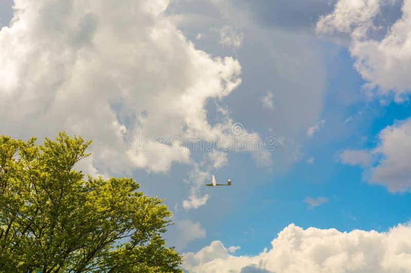 A Glider Flying in Bleu Sky with Big White Clouds. the Glider is a ...